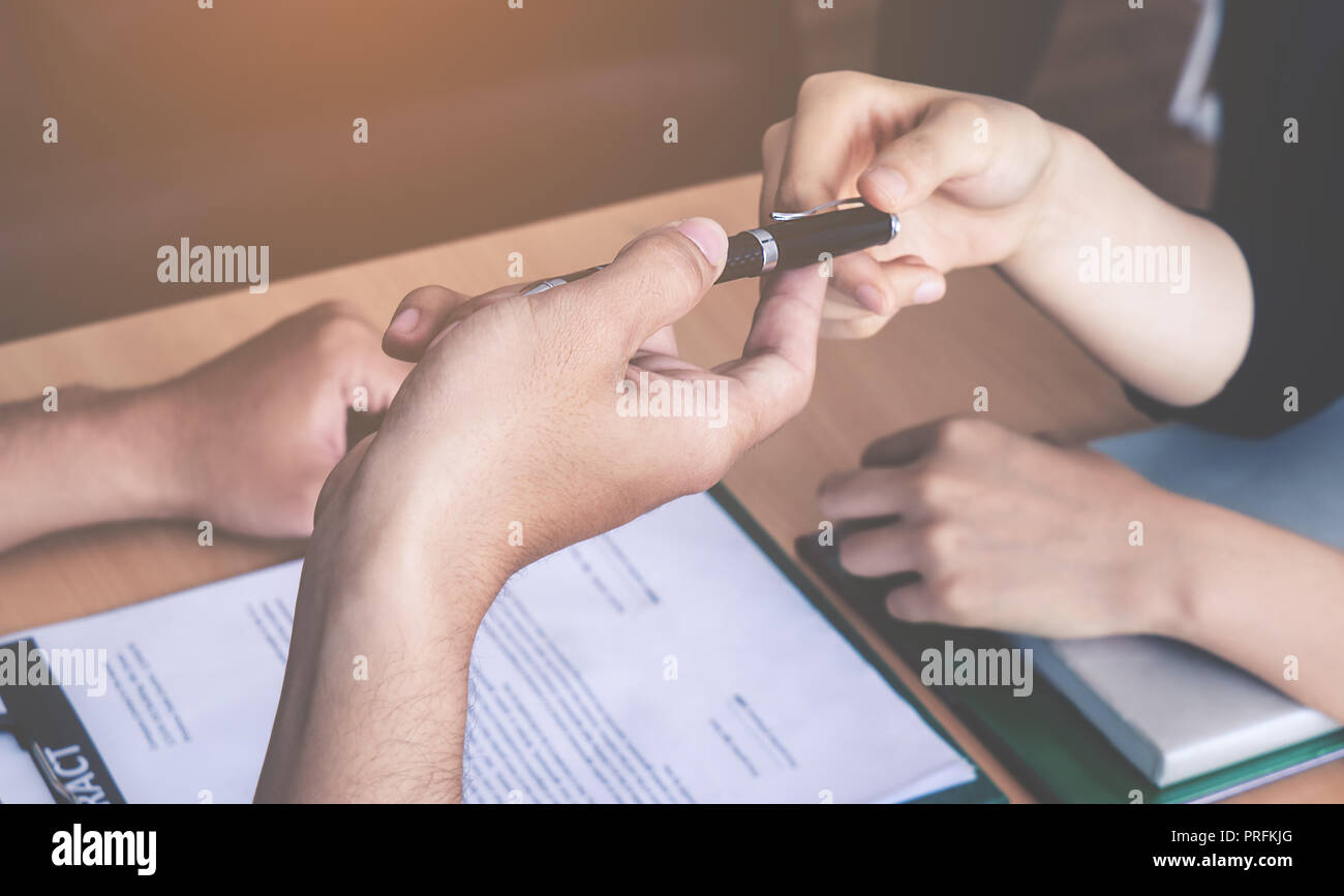 Business man is handing pen to a woman for contract signing Stock Photo ...