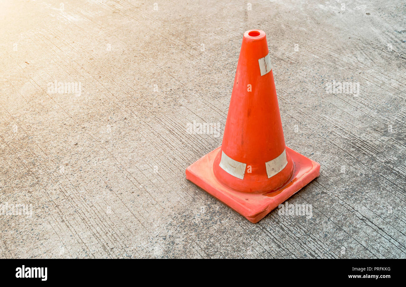Traffic cones are located on the cement surface. There is cement as ...
