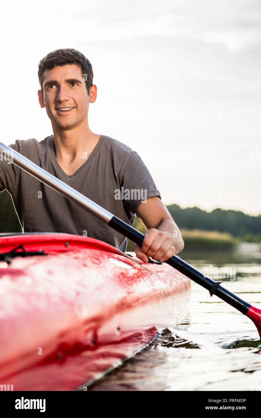 Smiling man rowing in kayak Stock Photo - Alamy