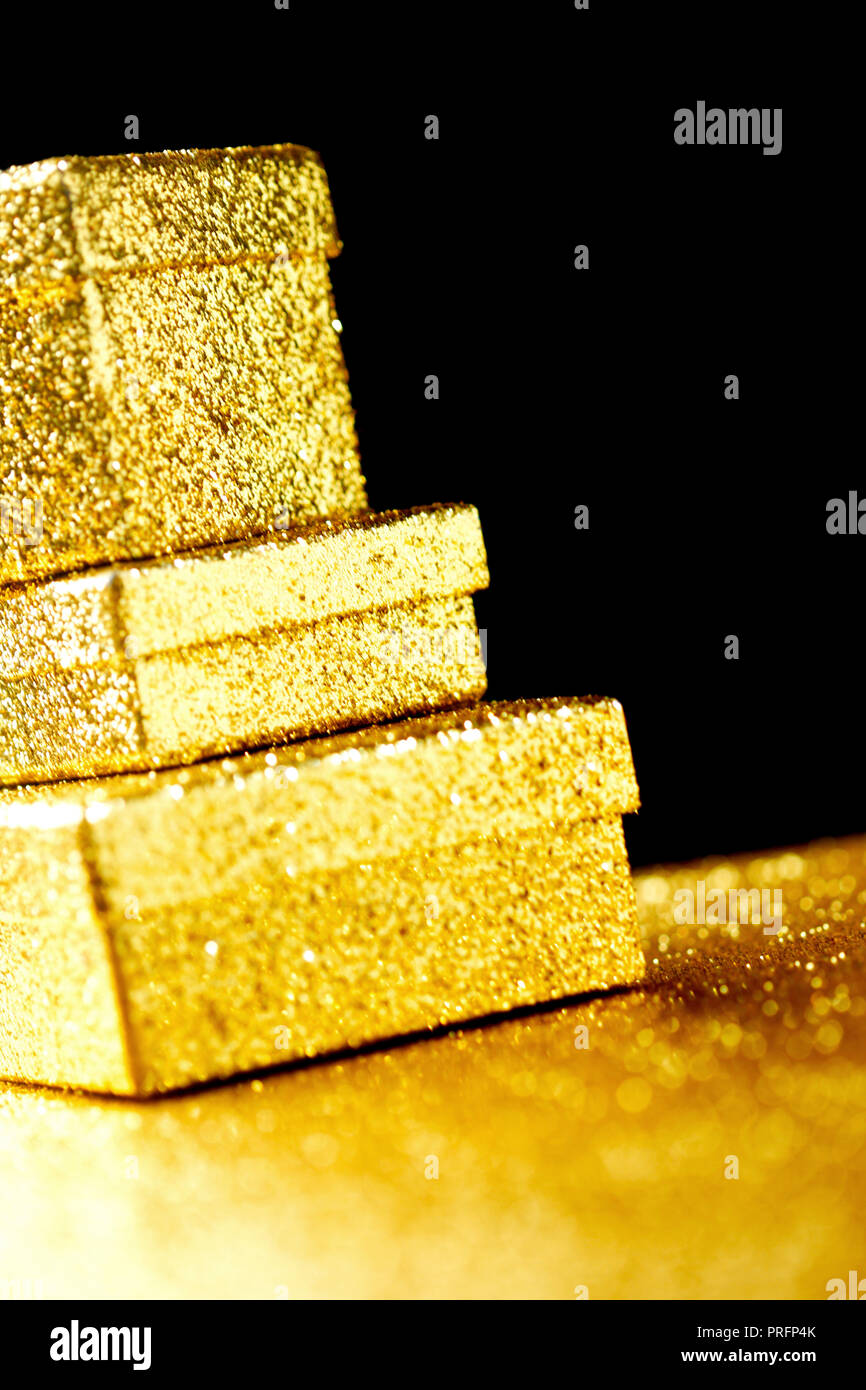 Decorative golden boxes with holiday gifts on shiny glitter background ...