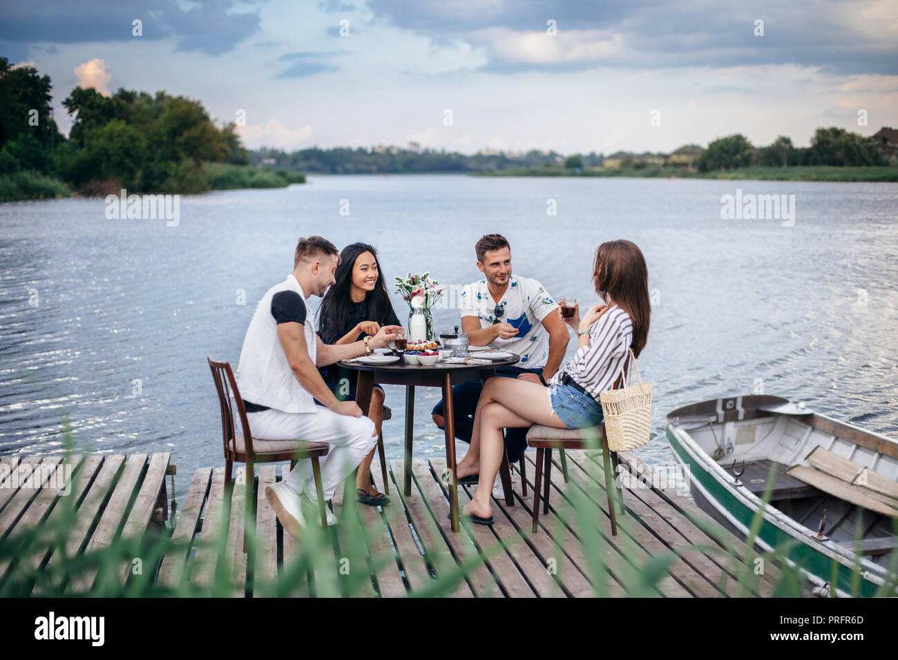 Group of happy friends gathering to having dinner together at summer ...