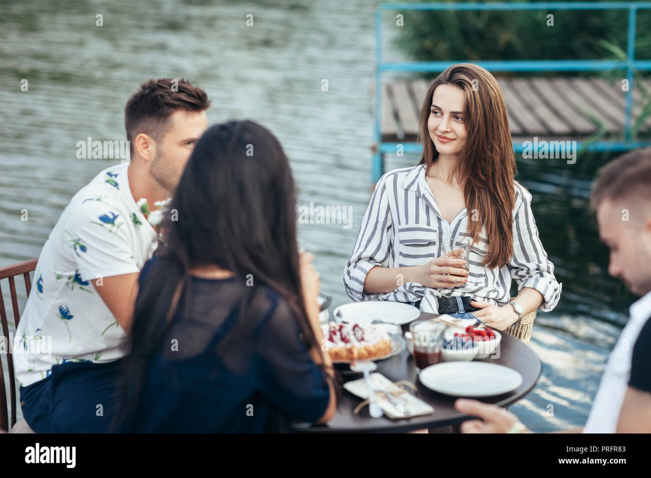 Friends enjoying meal during the dinner in outdoor restaurant. Food ...