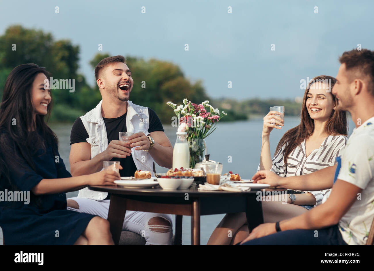 Happy friends having fun during the dinner in outdoor restaurant. Food ...