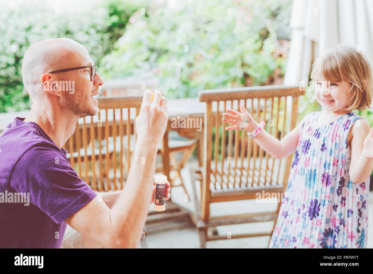 father and female child outdoor playing bubble soap - togetherness ...