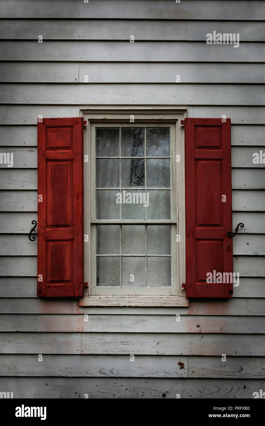 An old paned glass window is surrounded by peeling paint on wooden ...