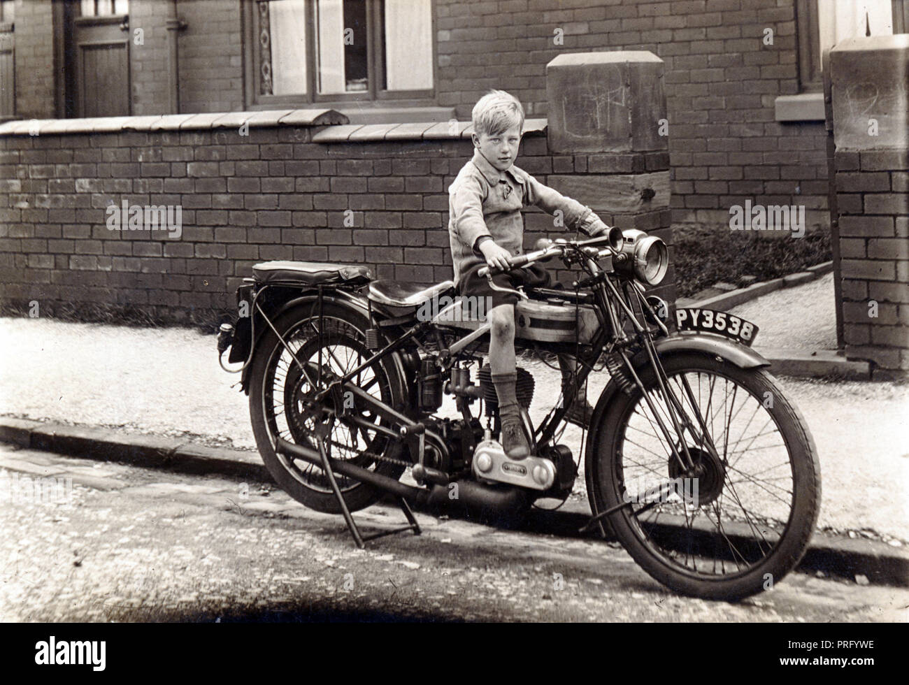 Little boy sitting on the petrol tank of a 1923/4 Triumph 350cc ...