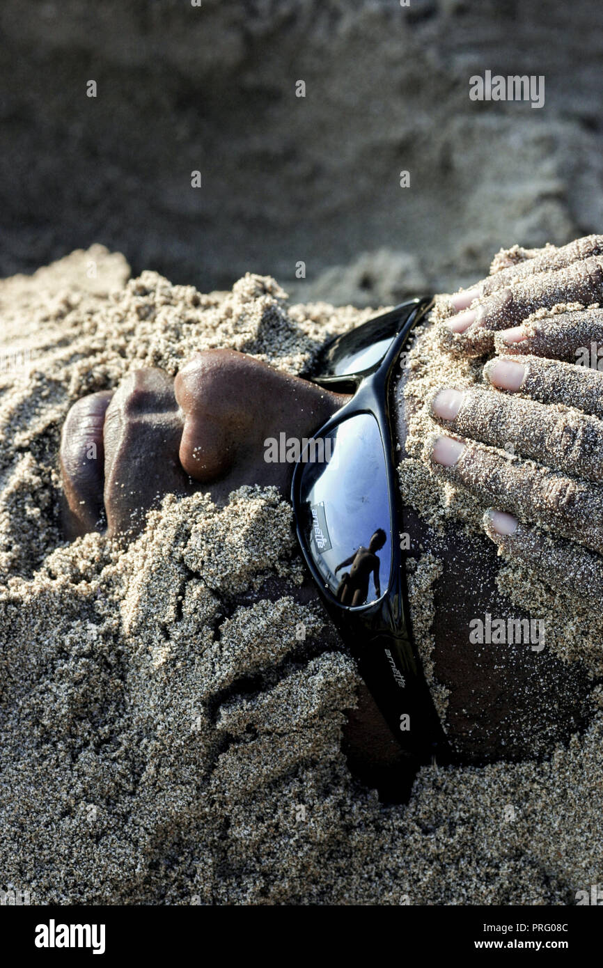 Man being buried in sand on Kuta Beach, Bali Stock Photo - Alamy
