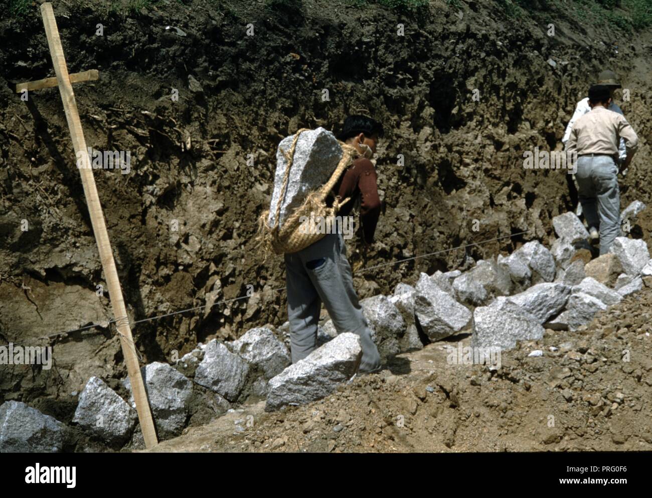 Japanese workers carrying stones and building retaining wall, 1965 ...