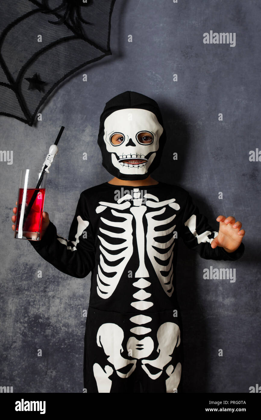 Little kid in a skeleton costume drinking fake blood on Halloween Stock ...