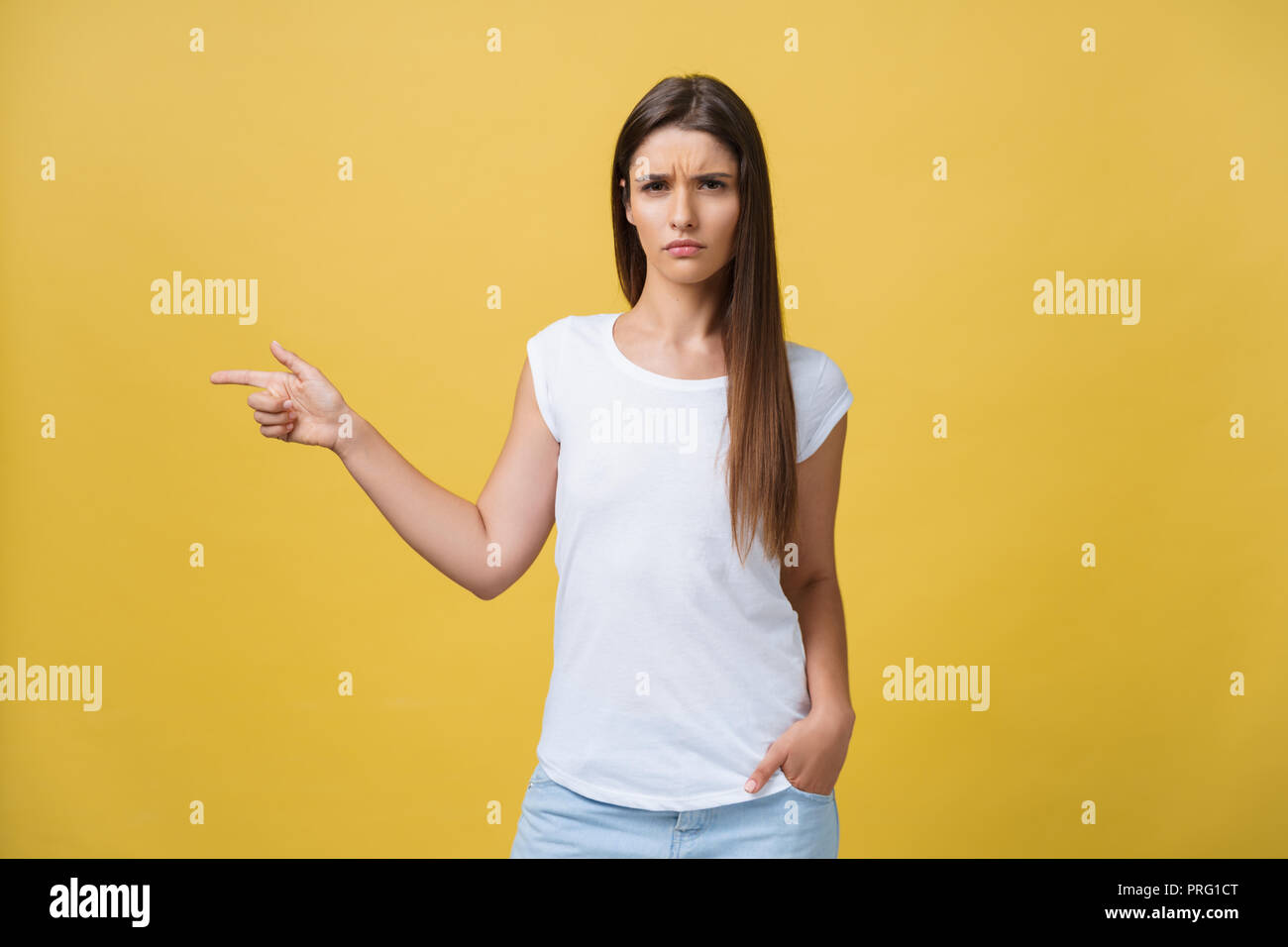 Closeup portrait of young pretty unhappy, serious woman pointing at ...
