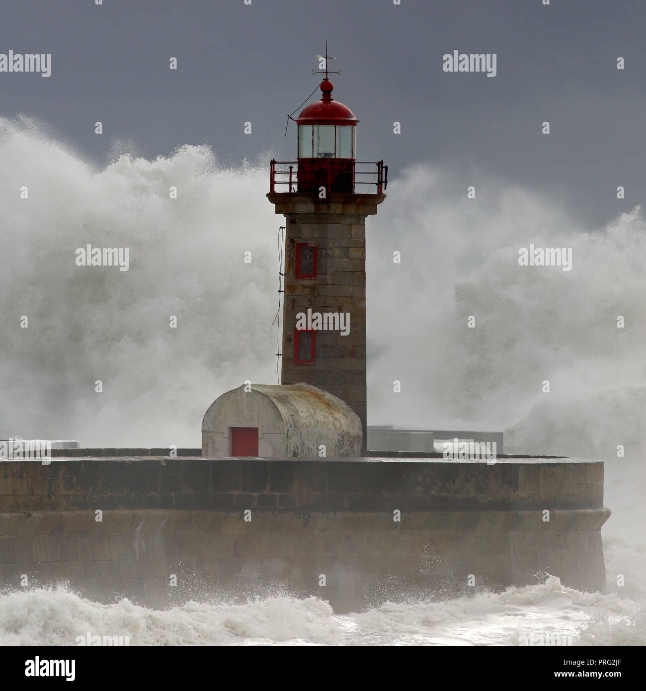 Huge Atlantic waves over Douro river old pier lighthouse in a stormy ...