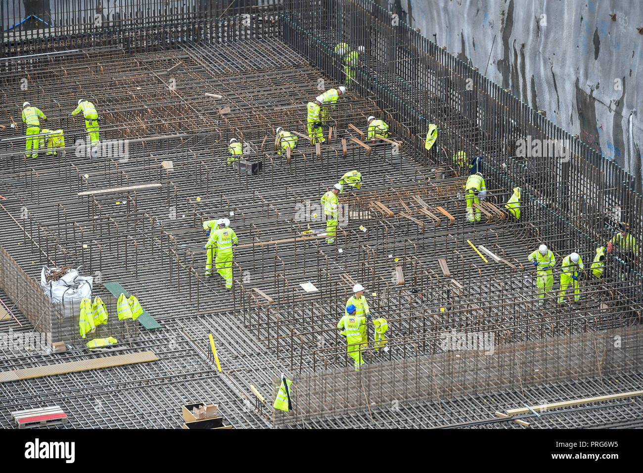 Construction workers fit reinforced concrete steel bars in the deep-dig ...