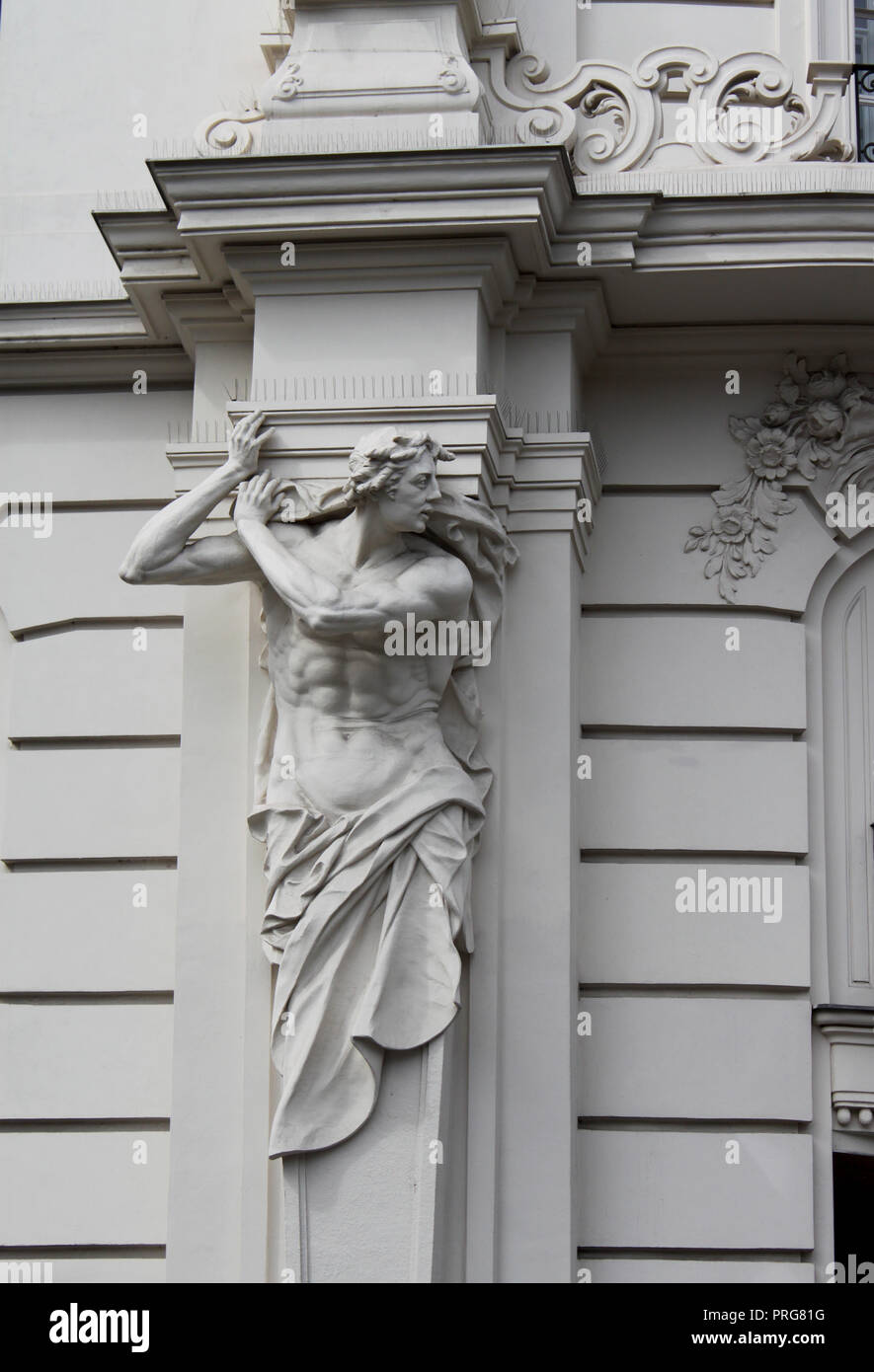A beautiful man statue on a historical building in the old town of ...