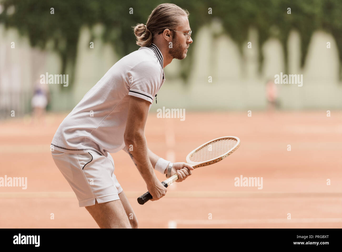 side view of handsome tennis player ready for game with racket at ...