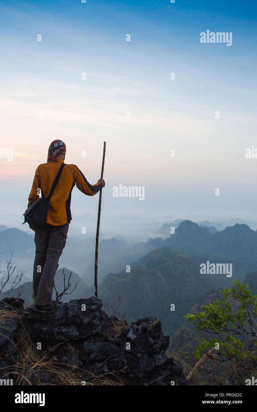 man sitting on stone top of high mountain Stock Photo - Alamy
