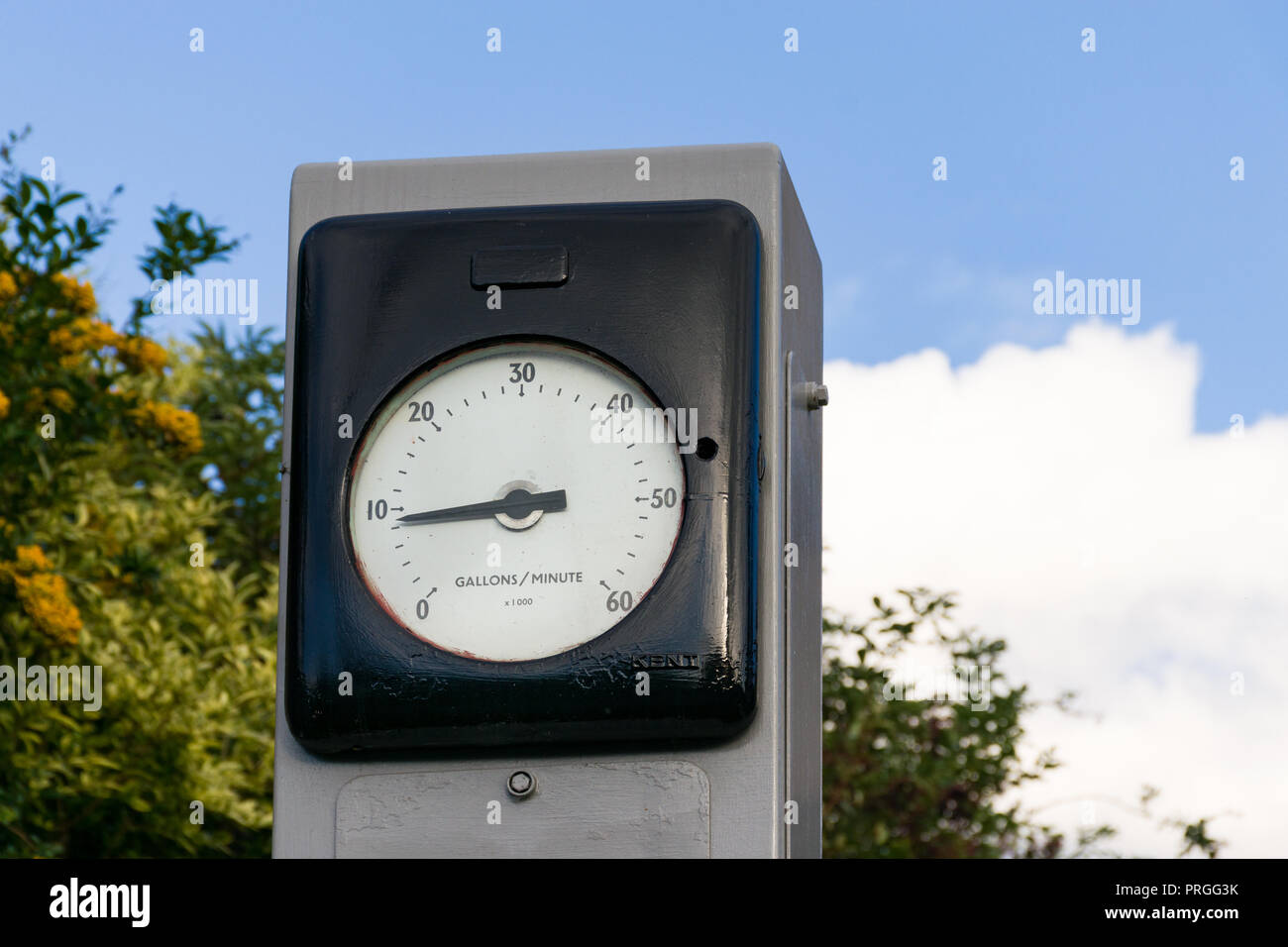 The front dial face of a large meter showing gallons per minute ...