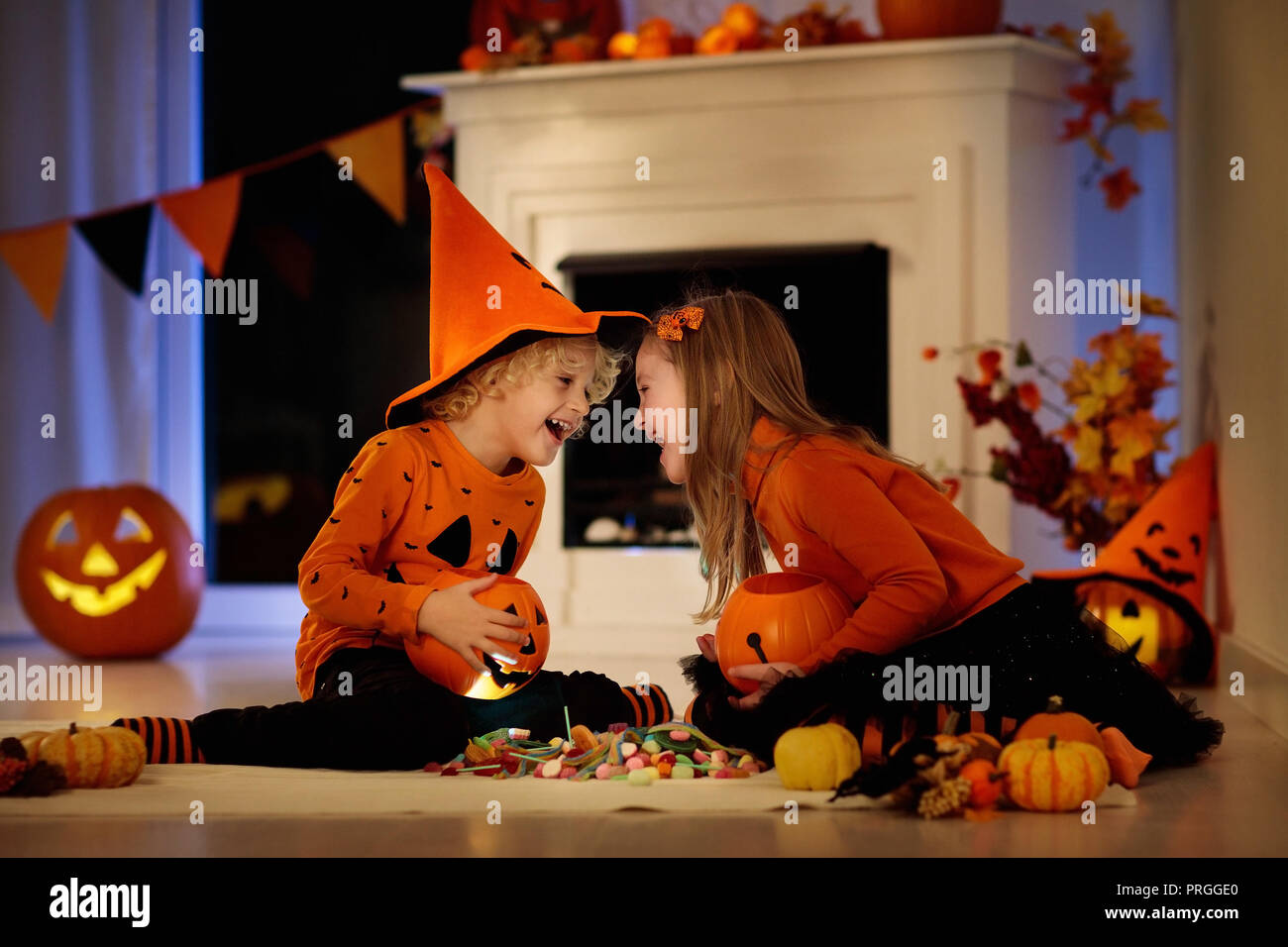 Little girl and boy in witch costume on Halloween trick or treat. Kids ...