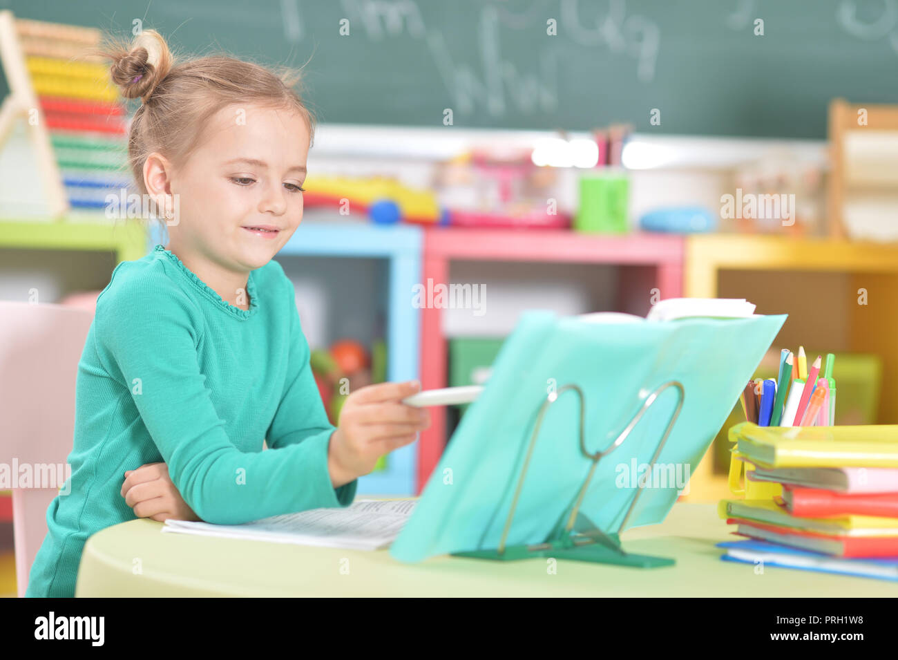 Cute happy schoolgirl doing homework Stock Photo - Alamy