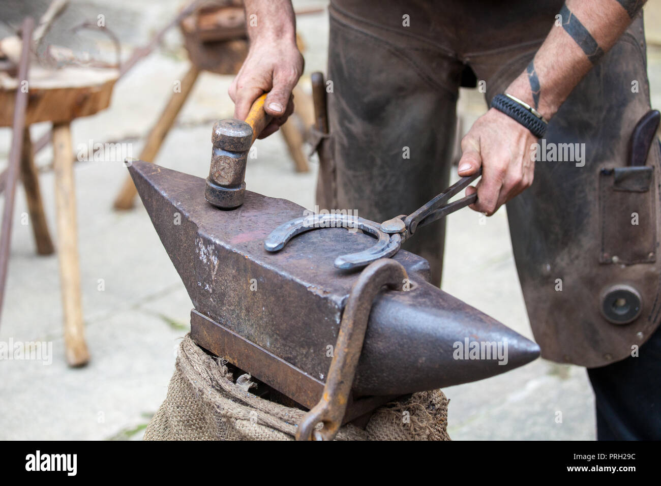 blacksmith being employed the iron at the anvil Stock Photo - Alamy