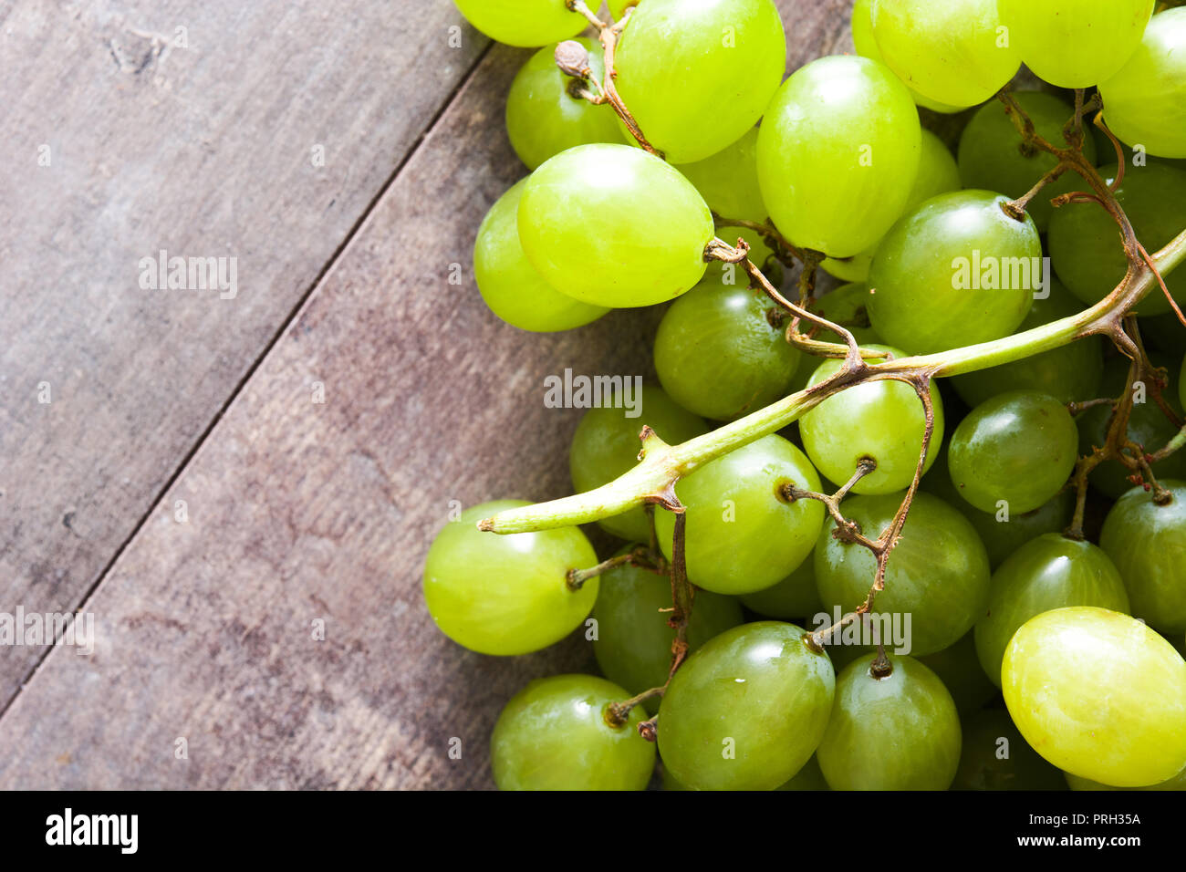 Green grapes on wooden table. Copyspace Stock Photo - Alamy