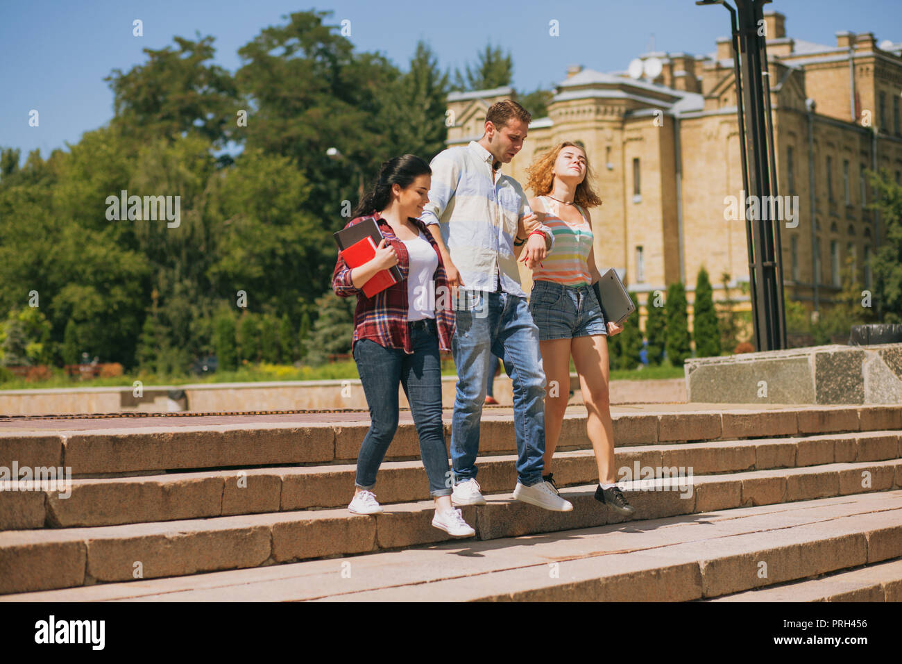 Happy students walking together Stock Photo - Alamy