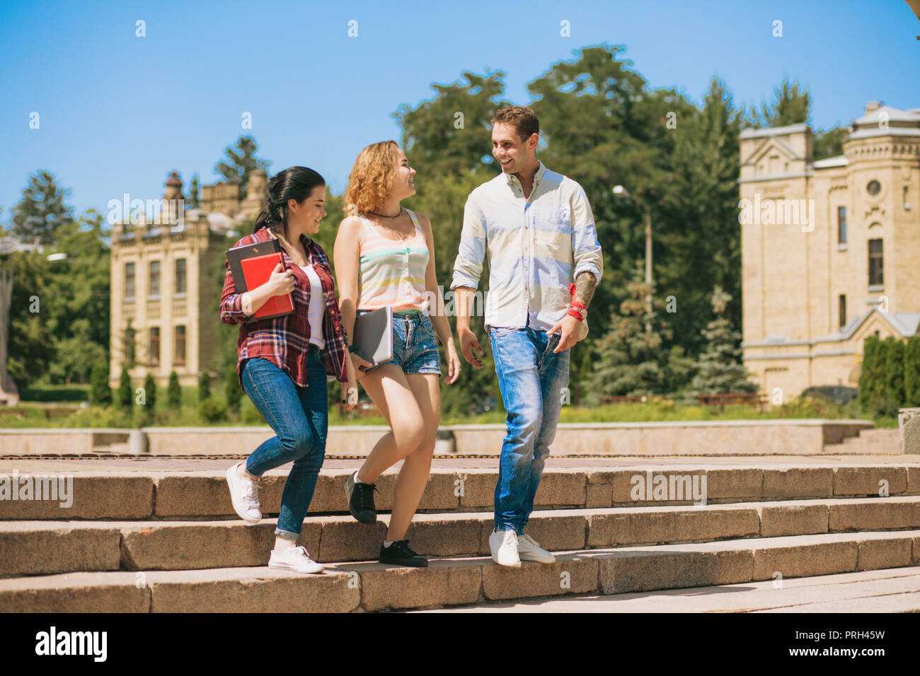 Happy students walking together Stock Photo - Alamy