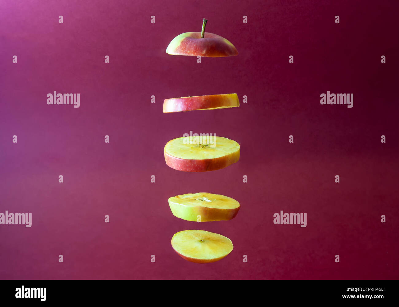 Flying Apple slices with red background Stock Photo - Alamy