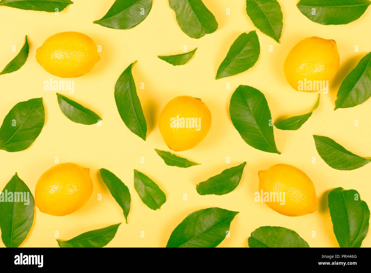 Five lemons with lemon tree leaves on yellow background Stock Photo - Alamy