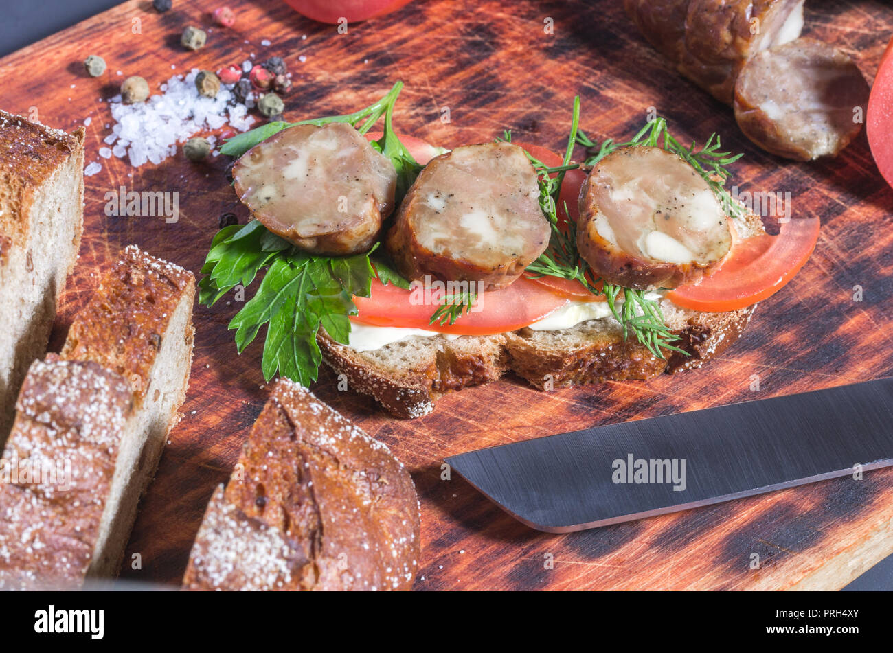 Making sandwiches. Cutting sausage. Sandwich with meat and vegetables ...