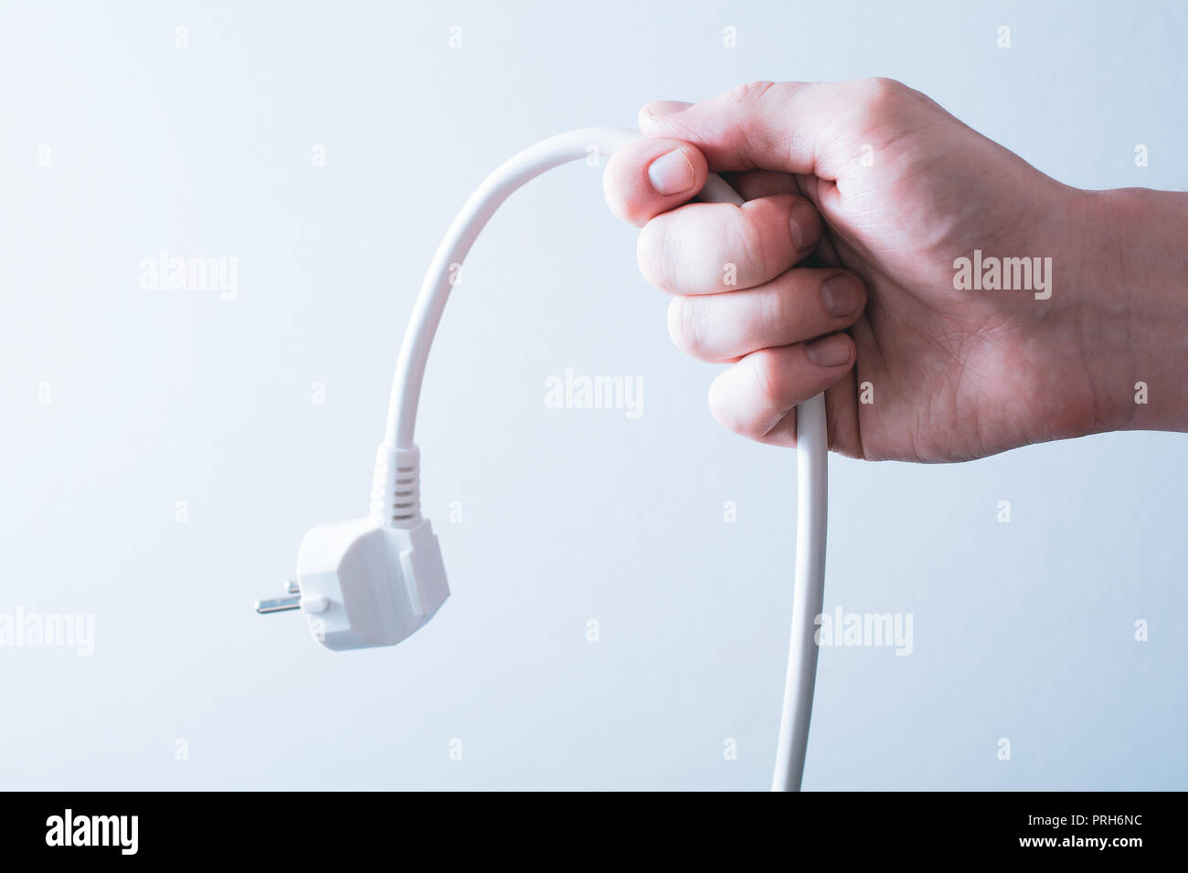 Male Hand Holding A Power Cable - Saving Energy Concept Stock Photo - Alamy