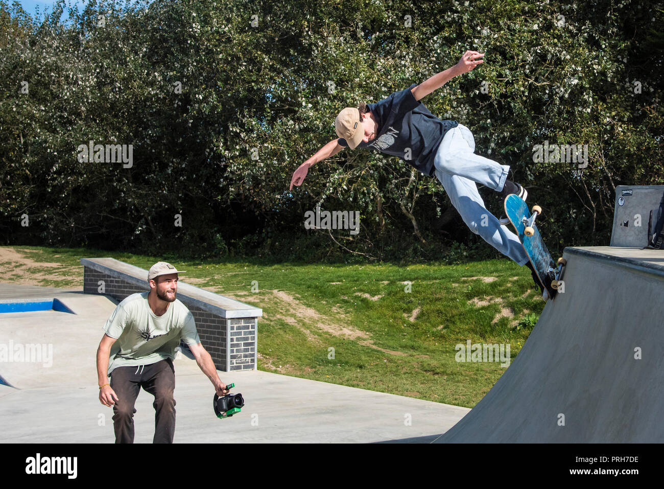 A skateboarder being filmed performing a trick on a ramp at Concrete ...