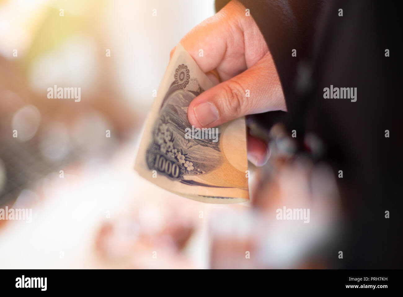 hand holding Japan Yen cash money to pay for shopping Stock Photo - Alamy