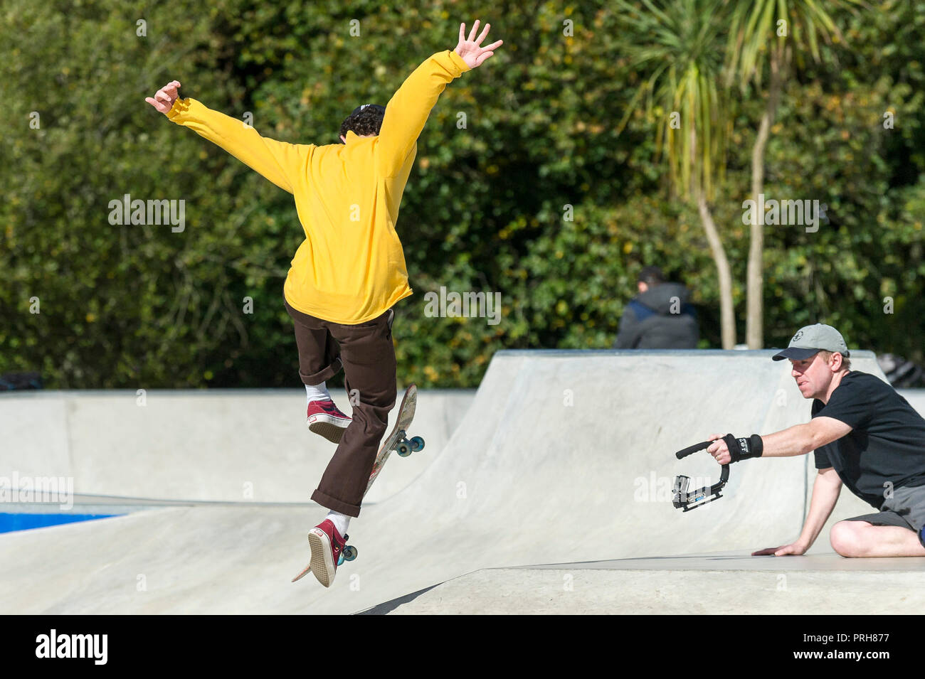 A skateboarder being filmed performing an aerial trick at Concrete ...