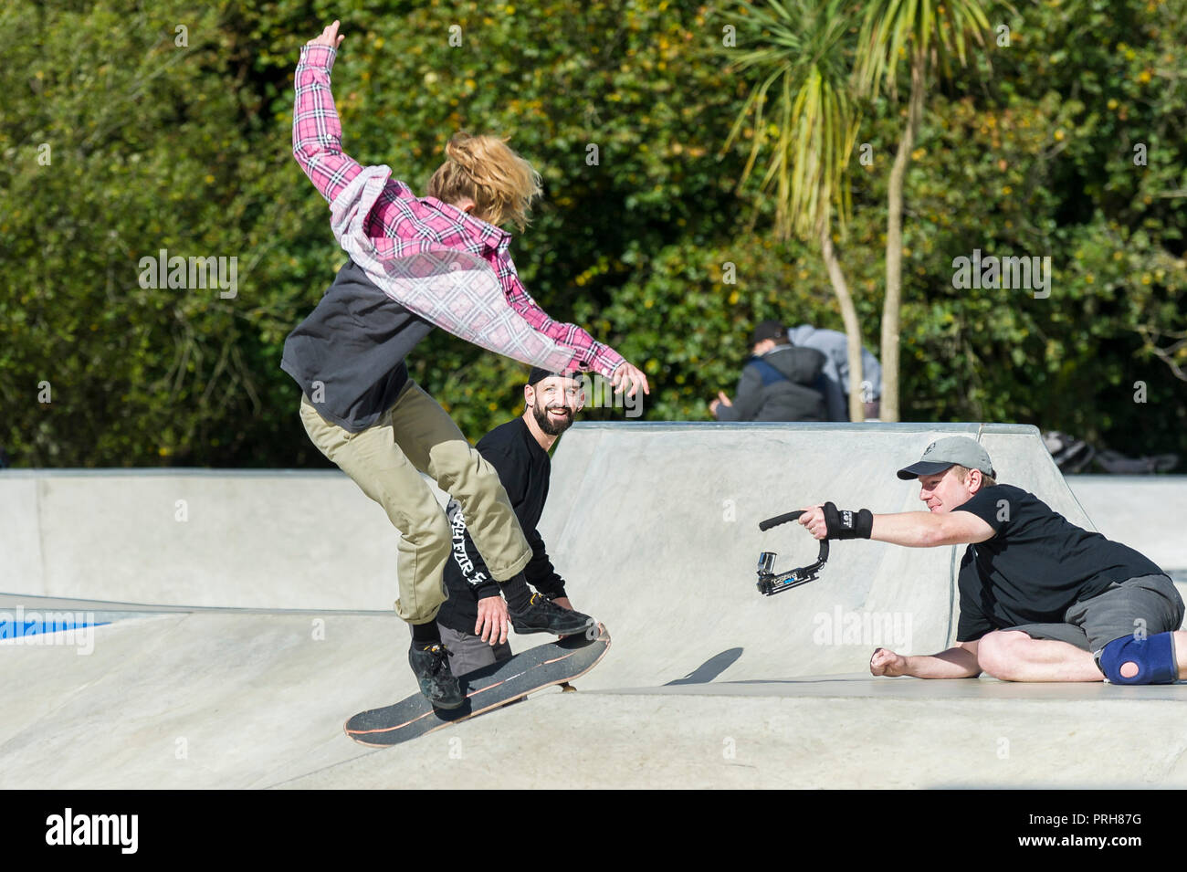 A female skateboarder being filmed performing a trick at Concrete Waves ...