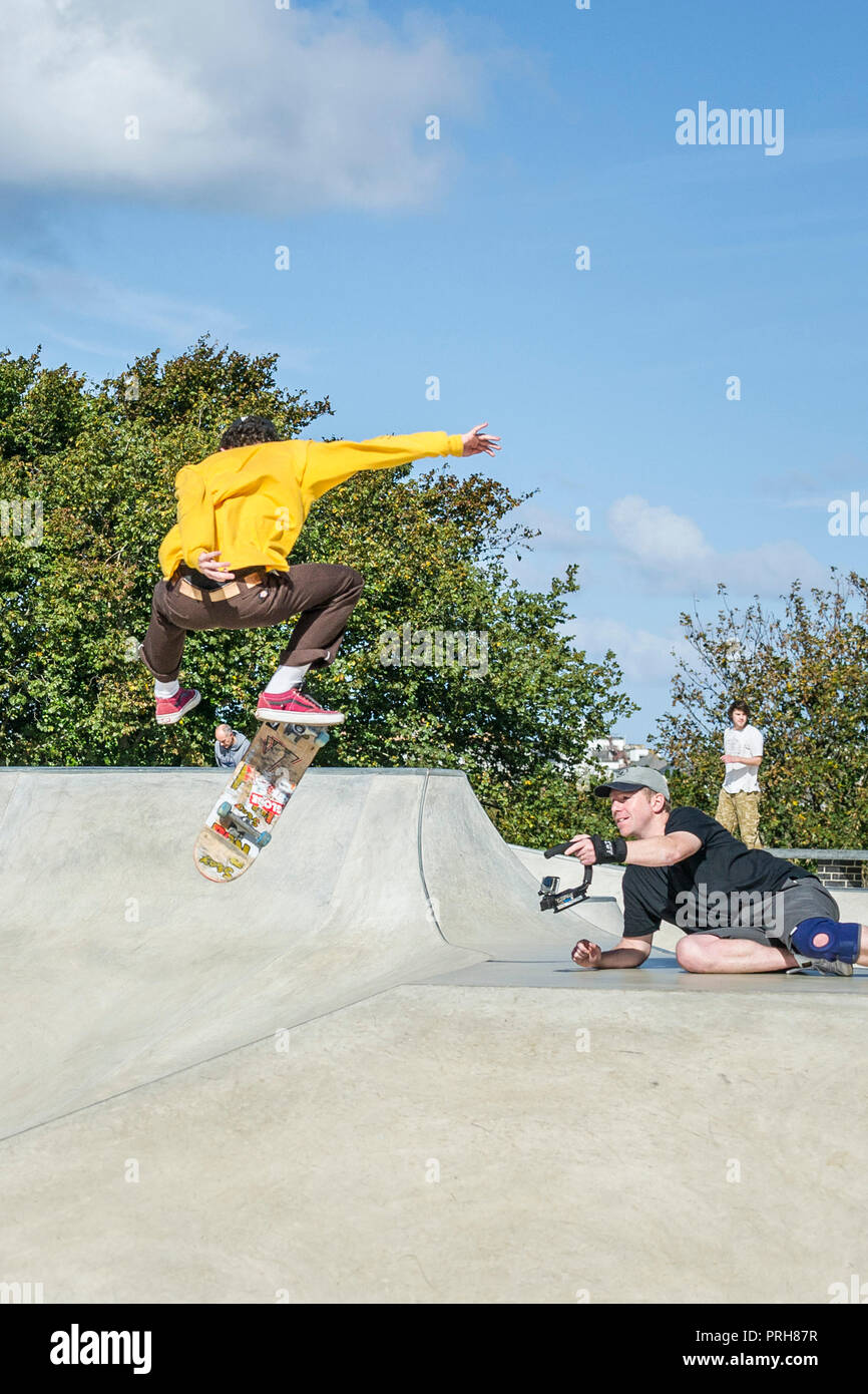 A skateboarder being filmed performing an aerial trick at Concrete ...