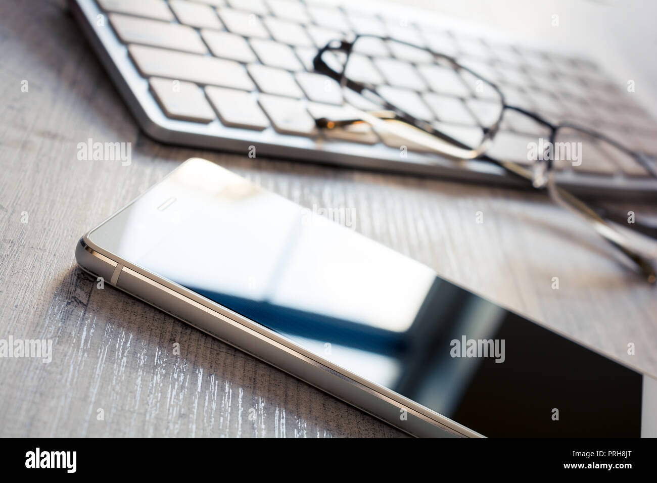Mobile Phone With Reflection, A Pair Of Glasses And A White Keyboard On ...