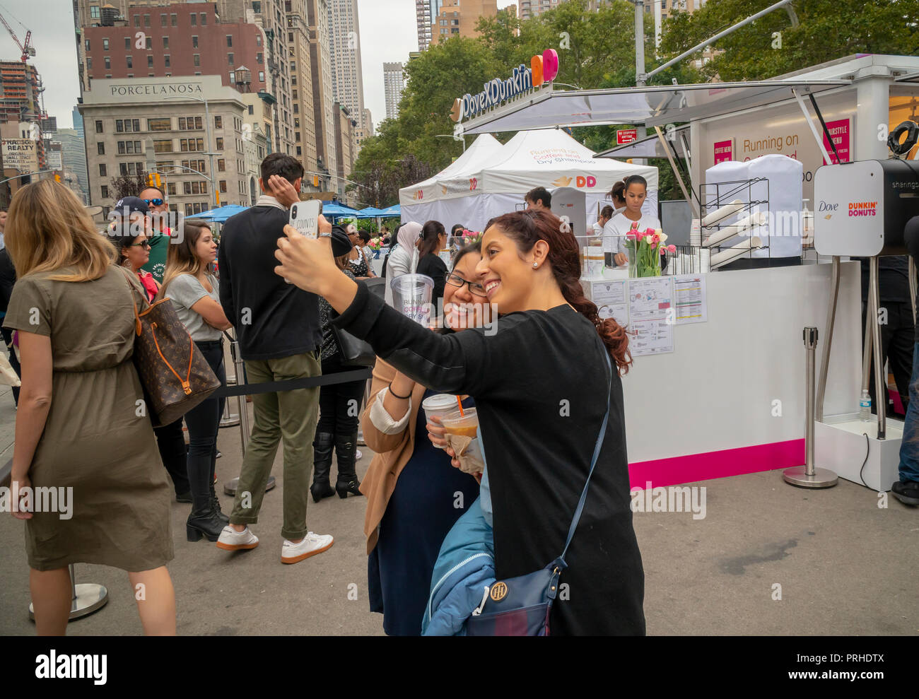 Millennials pose for a selfie at the Dunkin' and Dove collaboration ...