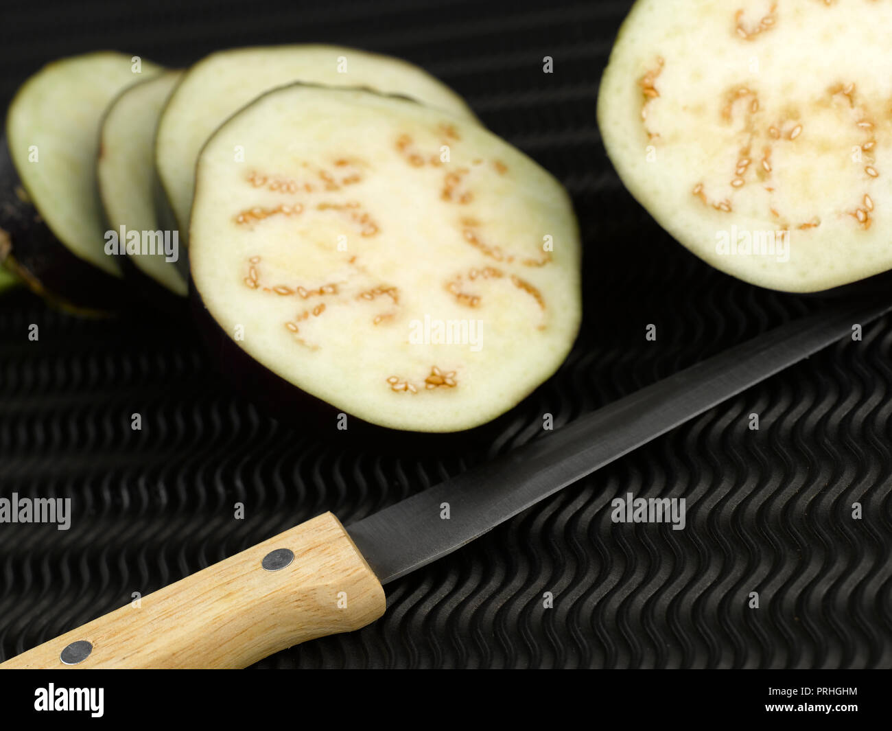 Brinjal, eggplant cut in slices on a black background Stock Photo - Alamy