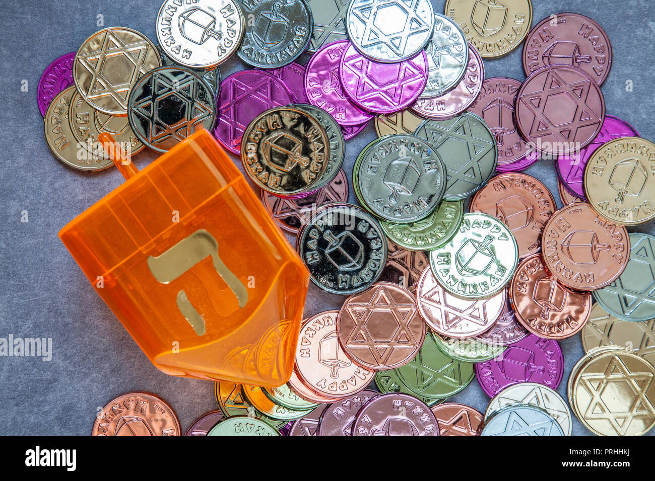 Large translucent orange plastic dreidl showing the Hebrew letter Hey ...