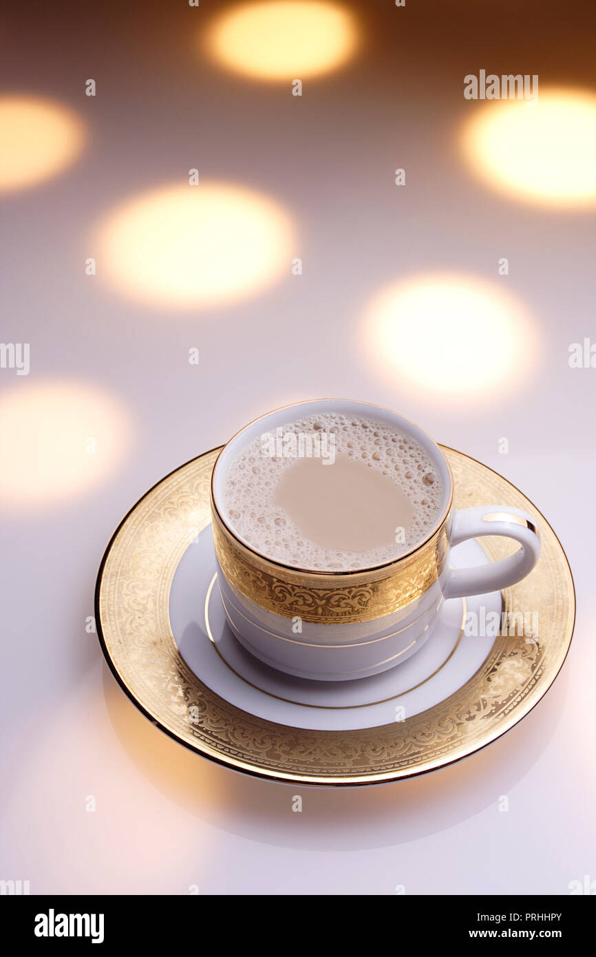 REGULAR COFFEE IN A ORNATE CUP AGAINST A GOLDEN BACKGROUND Stock Photo ...