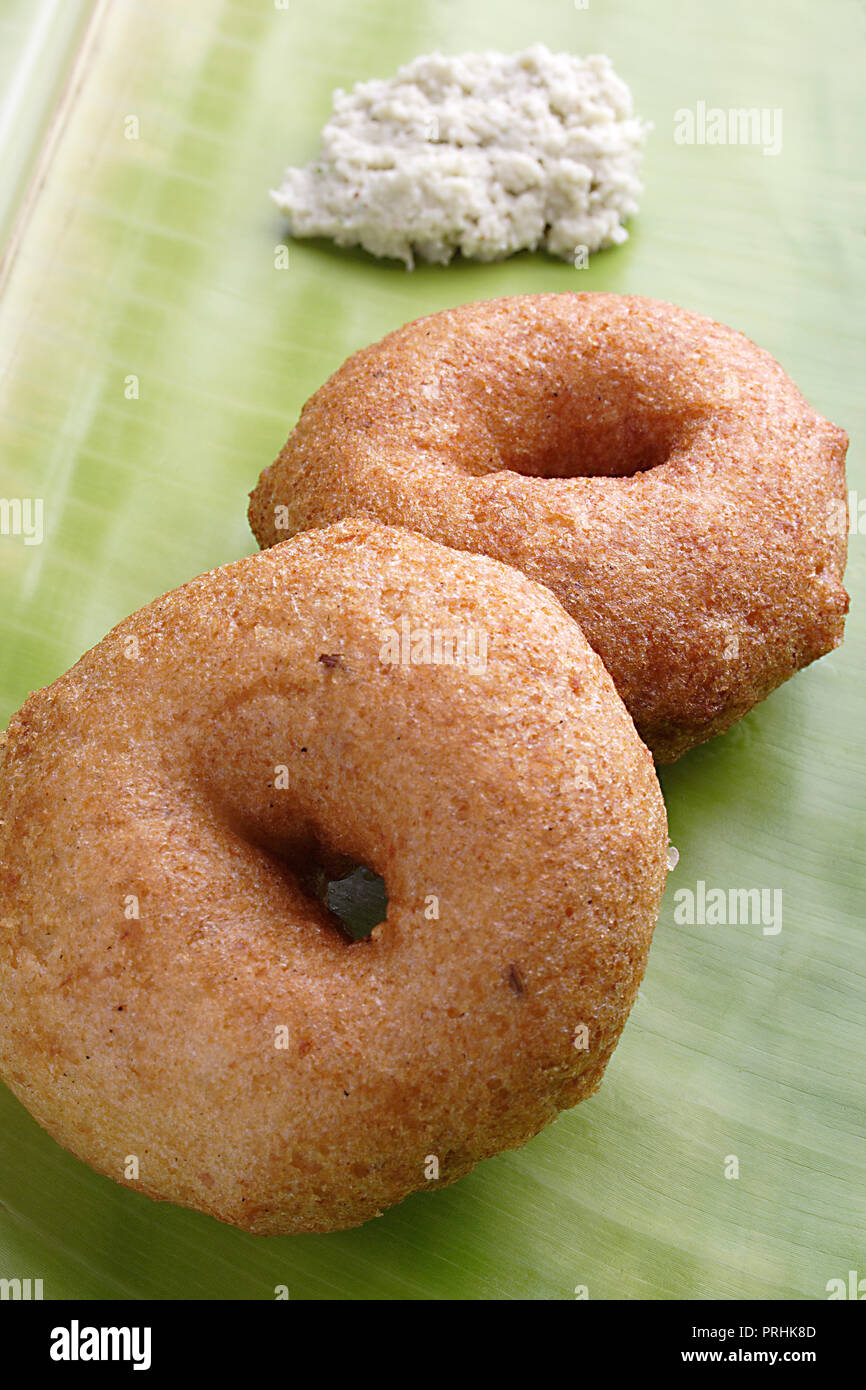 Meduwada on a banana leaf with chutney Stock Photo - Alamy
