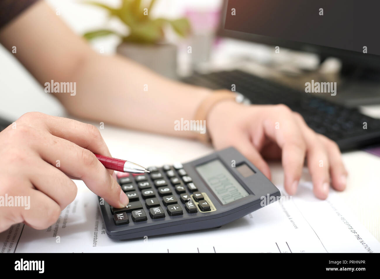 Man is using calculator with holding pen Stock Photo - Alamy