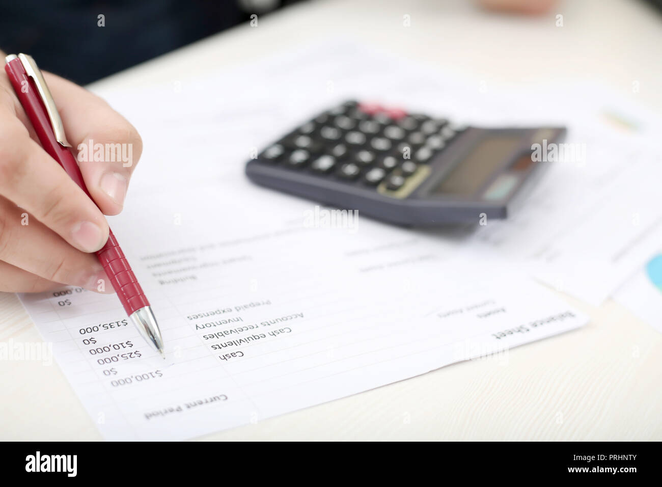 Man is checking account with pen and calculator Stock Photo - Alamy