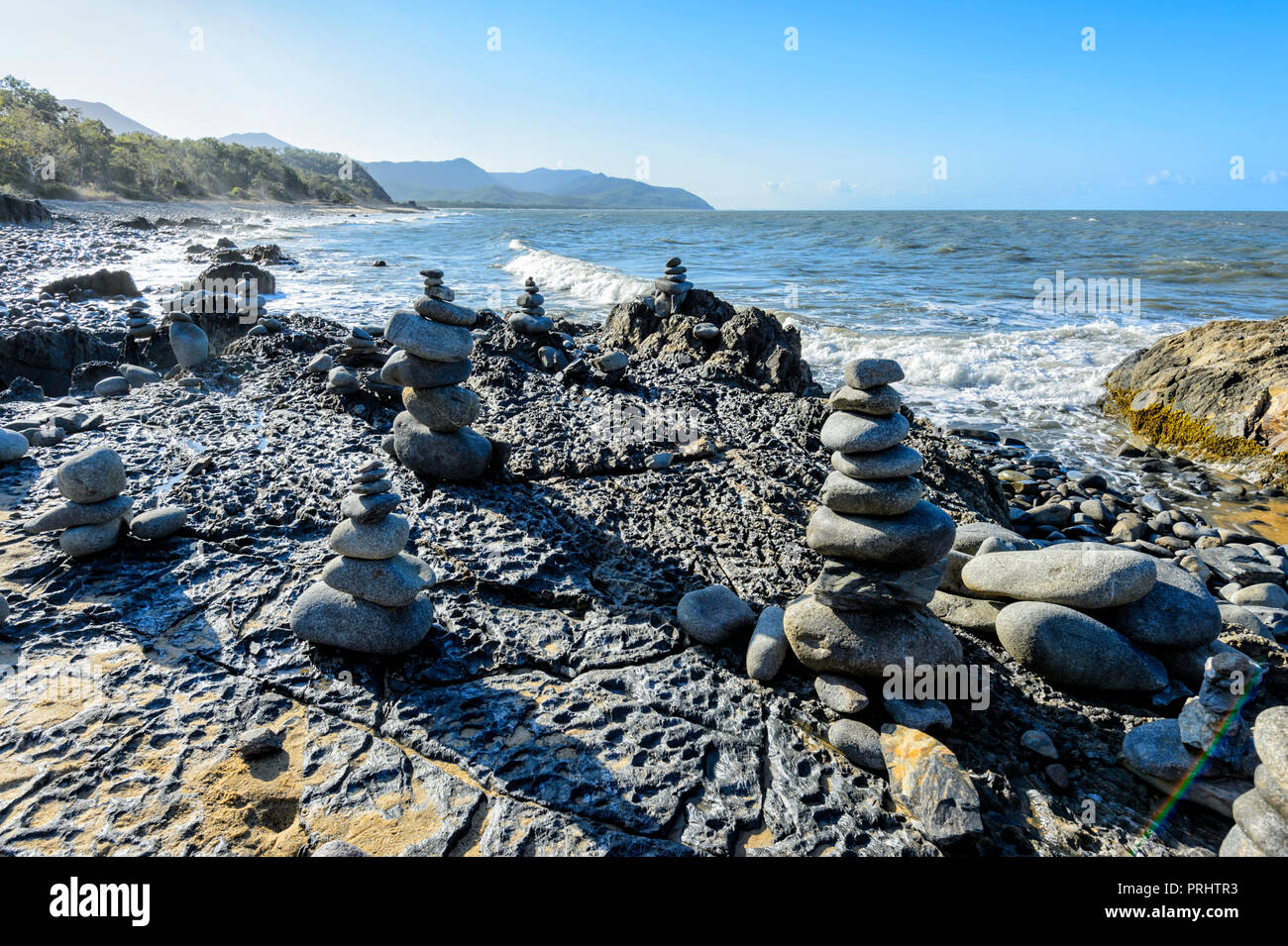 Scenic wild and rugged rocky coastline with stacked rocks along the Cpt ...