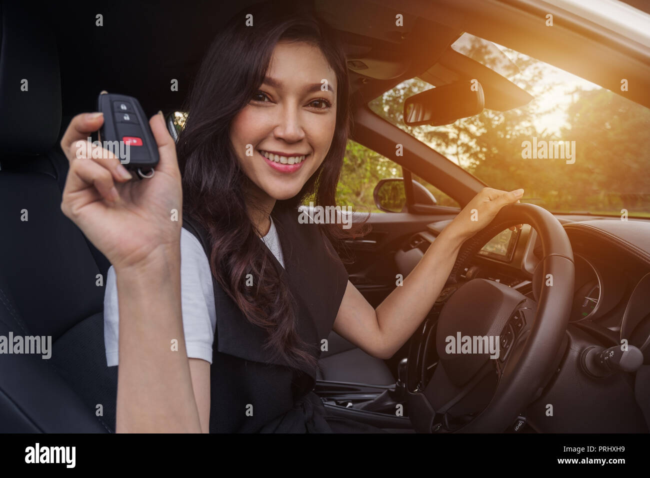 young woman with smart key remote in a car Stock Photo - Alamy