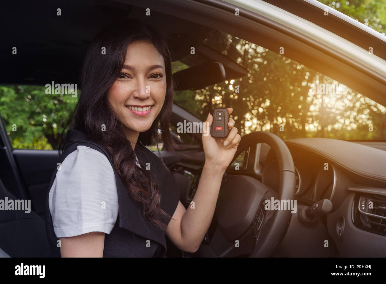 young woman with smart key remote in a car Stock Photo - Alamy
