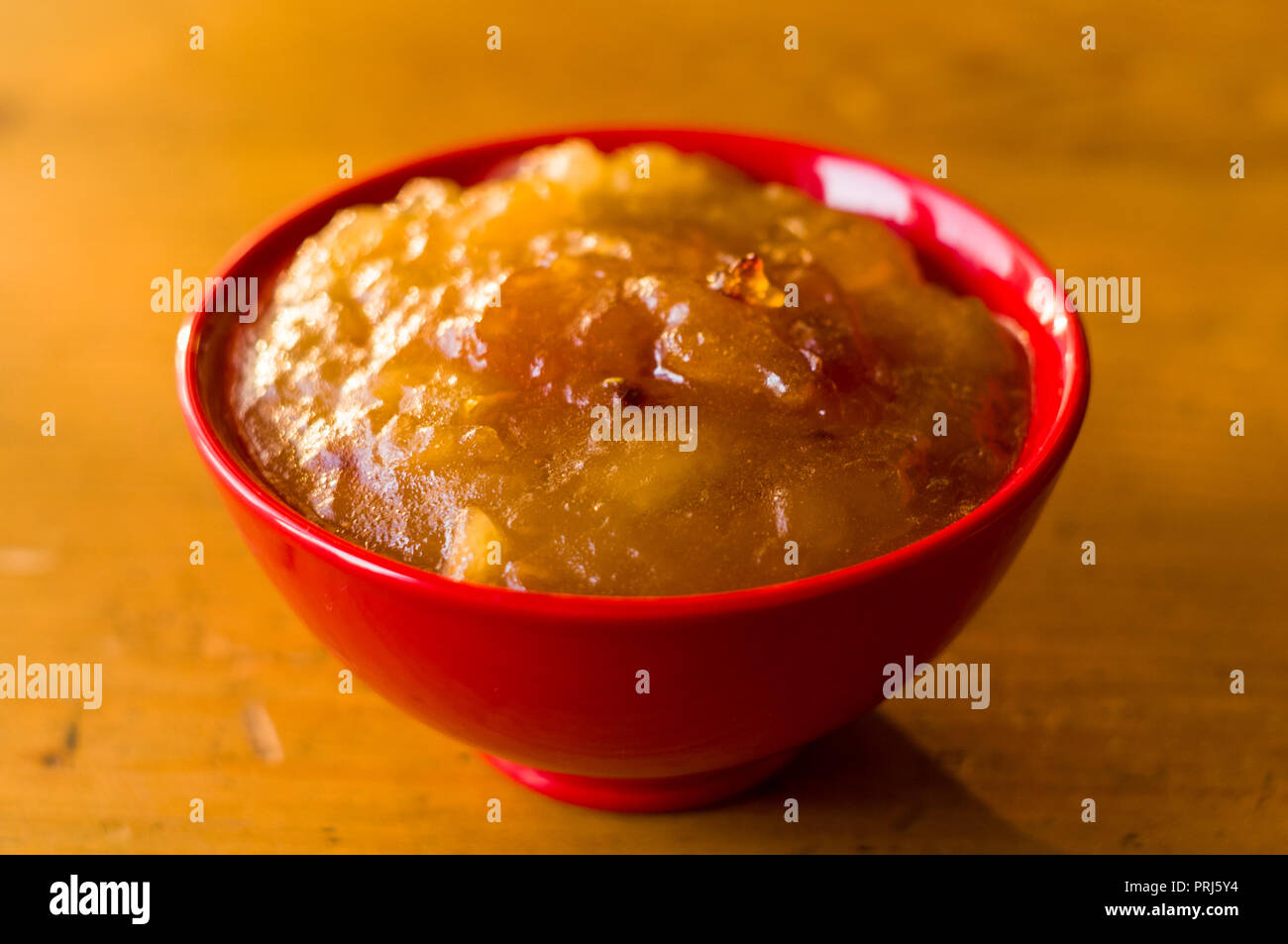Transparent Apple sweet homemade jam in the red ceramic bowl on wooden ...