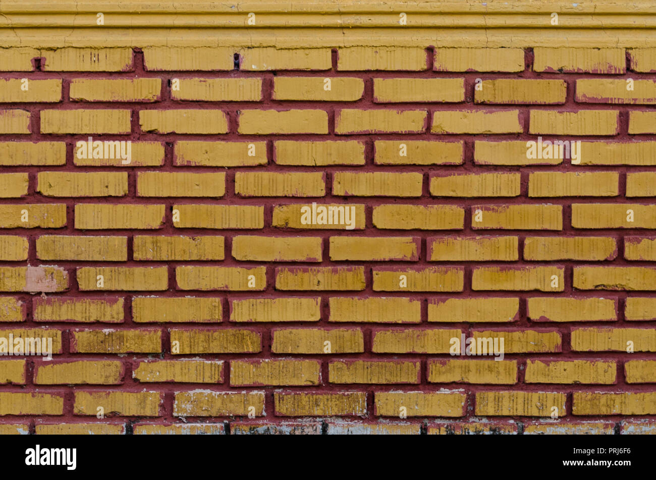 red brick wall with orange, giving a yellowish tone, on the sidewalk of ...