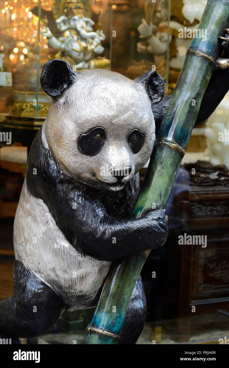 A bronze sculpture of a panda bear for sale in a souvenir and home ...