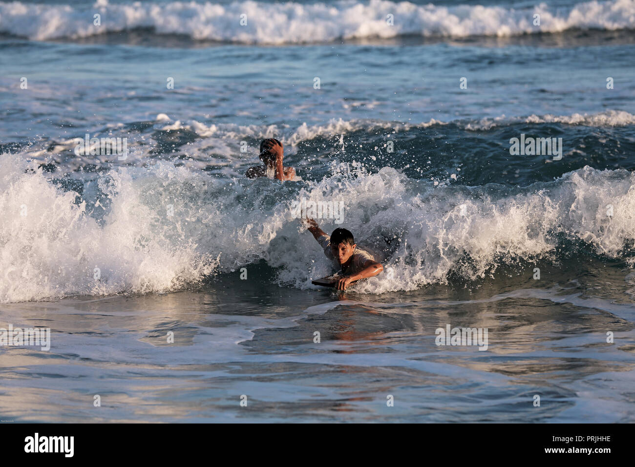Children surfing waves on pieces of wood in Sumatra, Indonesia Stock ...